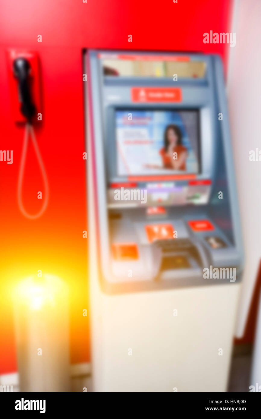 Photography of red cash dispenser in room Stock Photo - Alamy