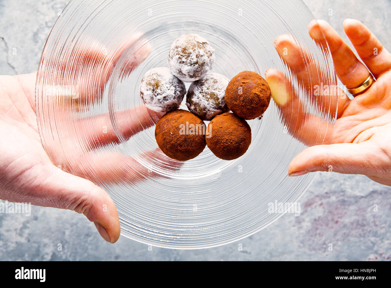 chocolate candy in hand on the transparent plate Stock Photo - Alamy