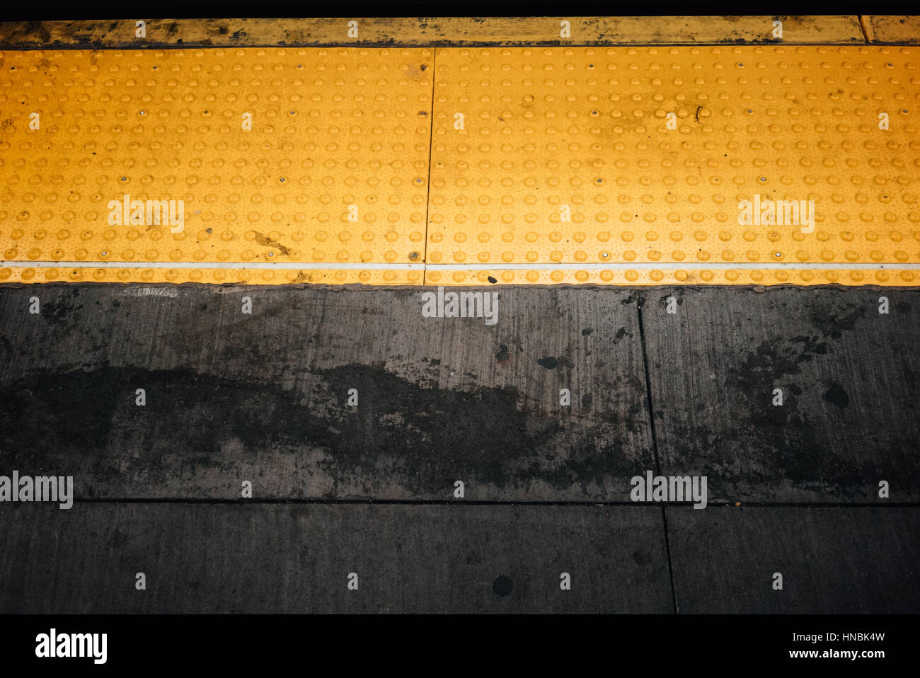 Yellow gap painted on train station's platform edge Stock Photo - Alamy
