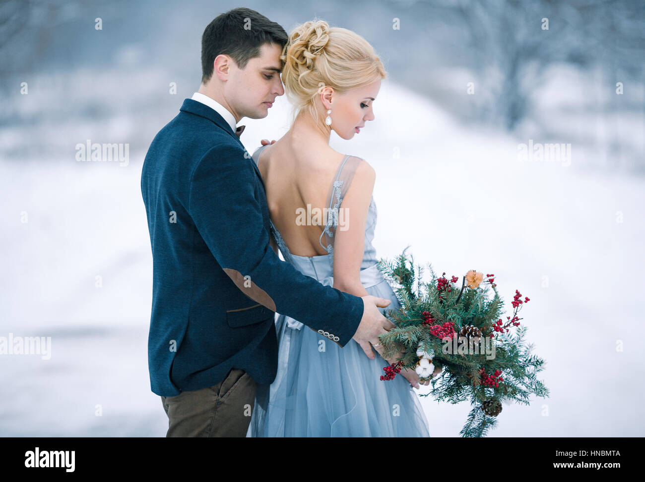 Bride and groom among snowy landscape. Bride and groom are standing and ...