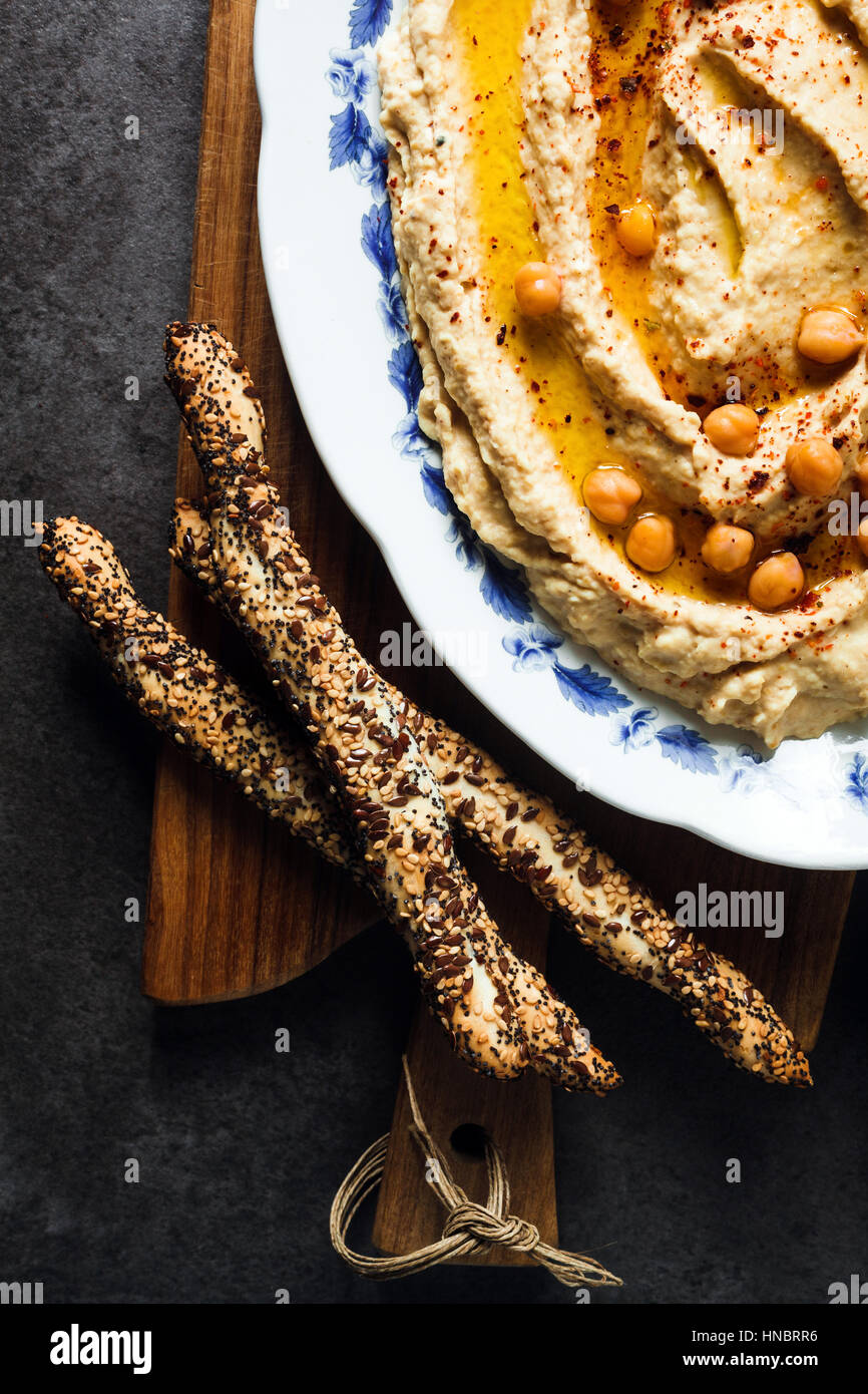 Healthy Homemade Creamy Hummus with Olive Oil and breadsticks with ...