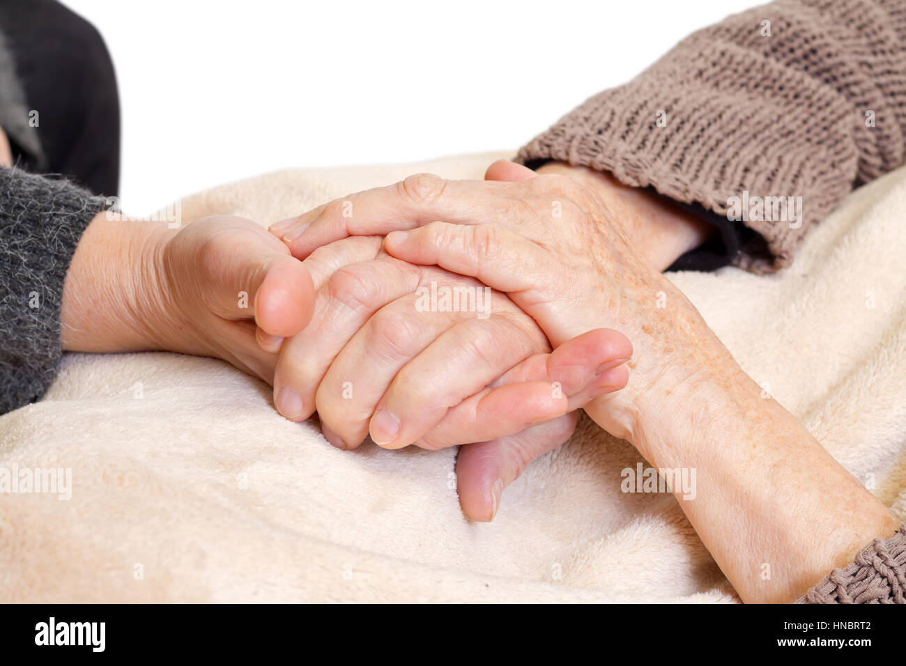 Doctor's hand holding a wrinkled elderly hand Stock Photo - Alamy