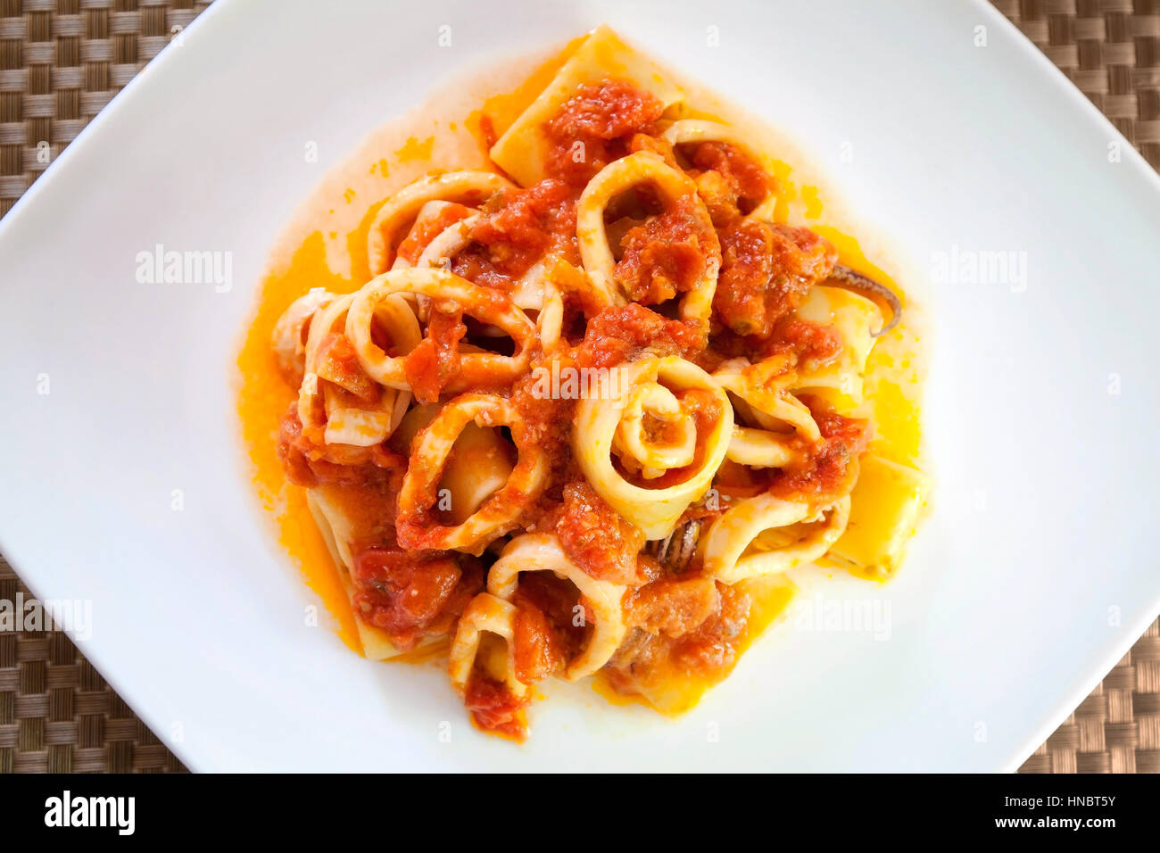 Squid, pasta with tomato sauce and squid cut ring. typical of ...