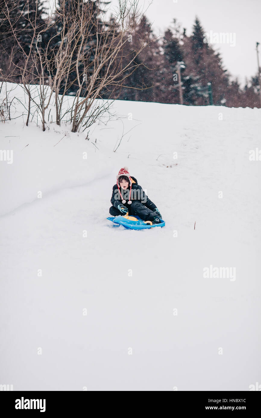 Boy sledding down hill hi-res stock photography and images - Alamy
