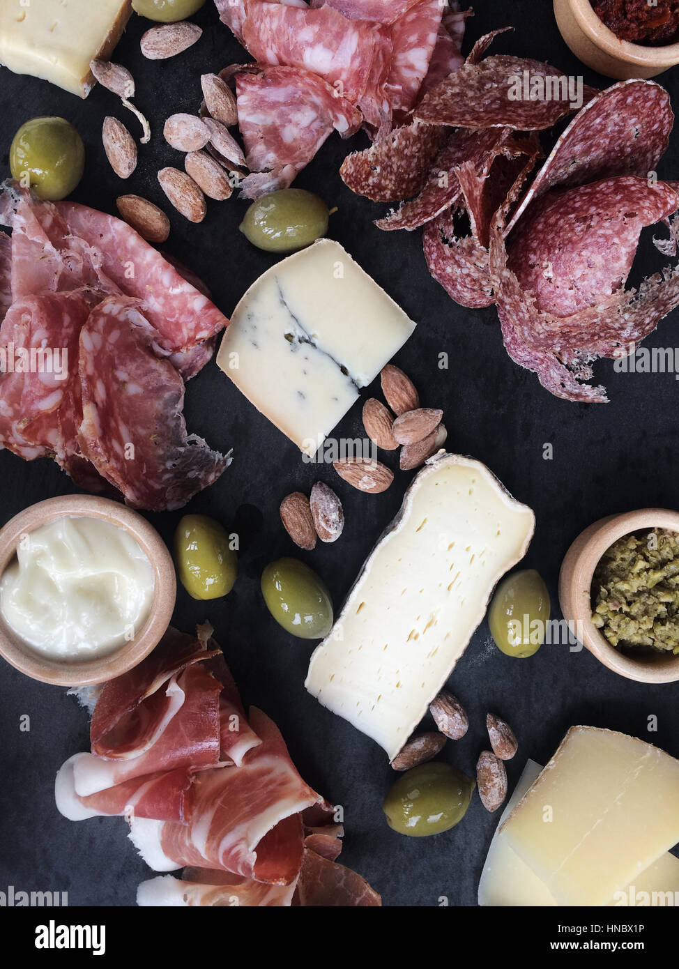 Overhead view of cheese, cured meats, olives and almonds Stock Photo ...