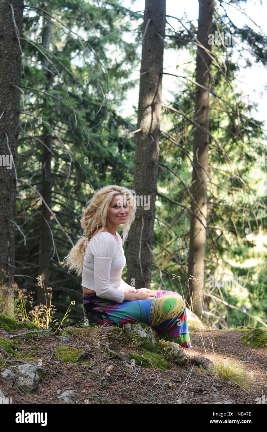 Woman sitting in forest Stock Photo - Alamy