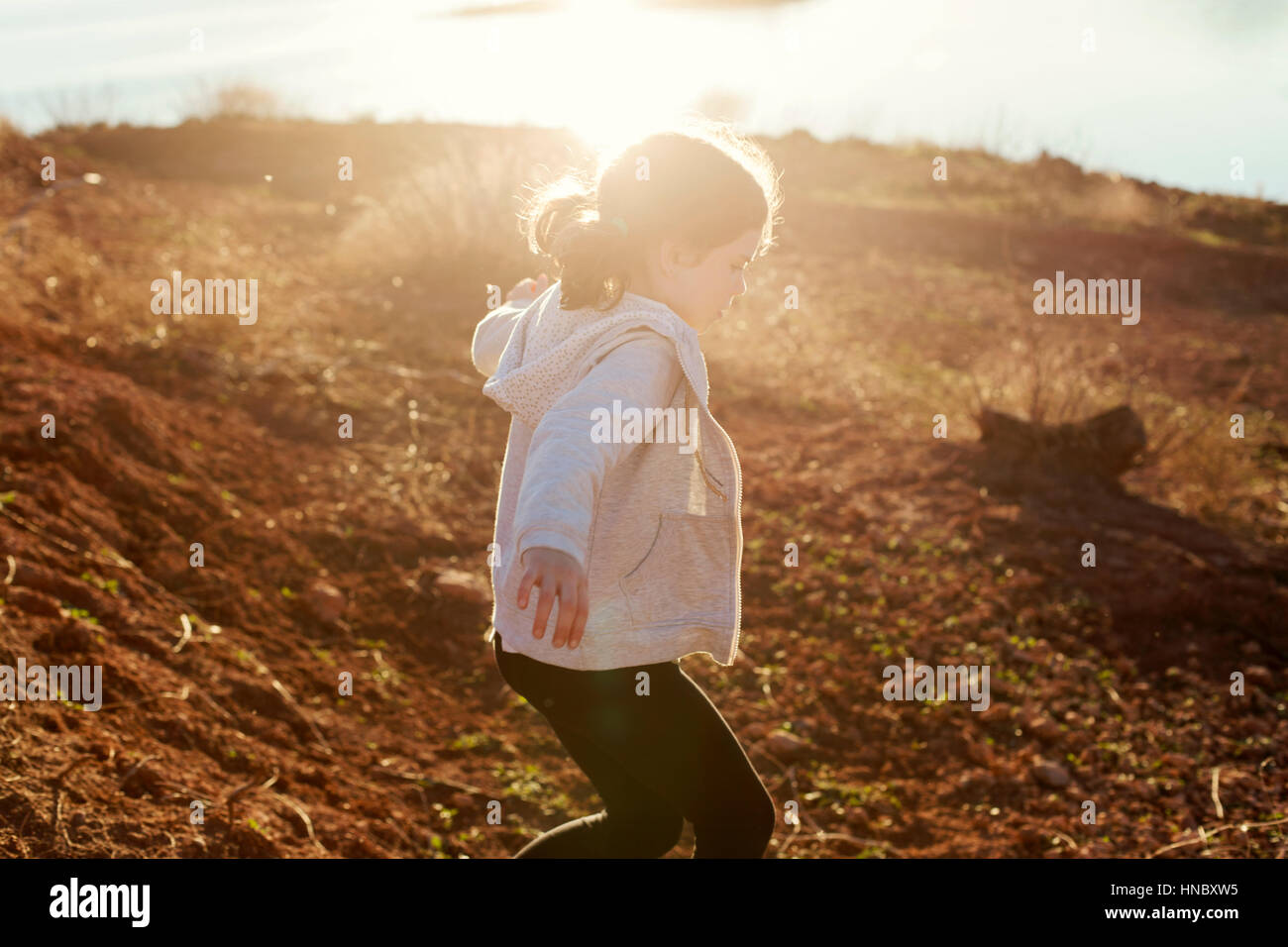 Girl running in a field at sunset Stock Photo - Alamy