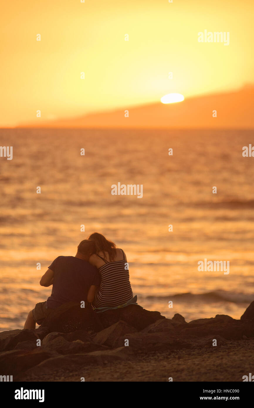 Couple in love on the beach at sunset Stock Photo - Alamy