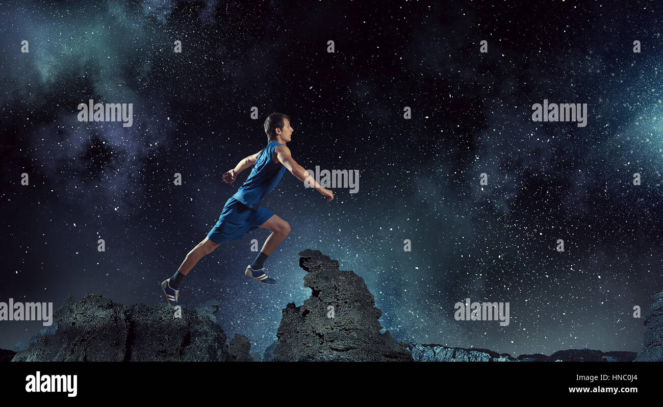 Young sportsman jogging against night sky background Stock Photo - Alamy