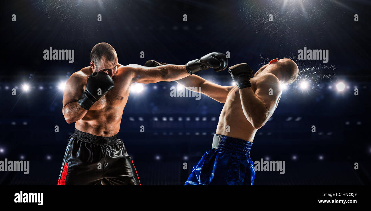 Two professional boxers fighting at sport arena. Mixed media Stock ...