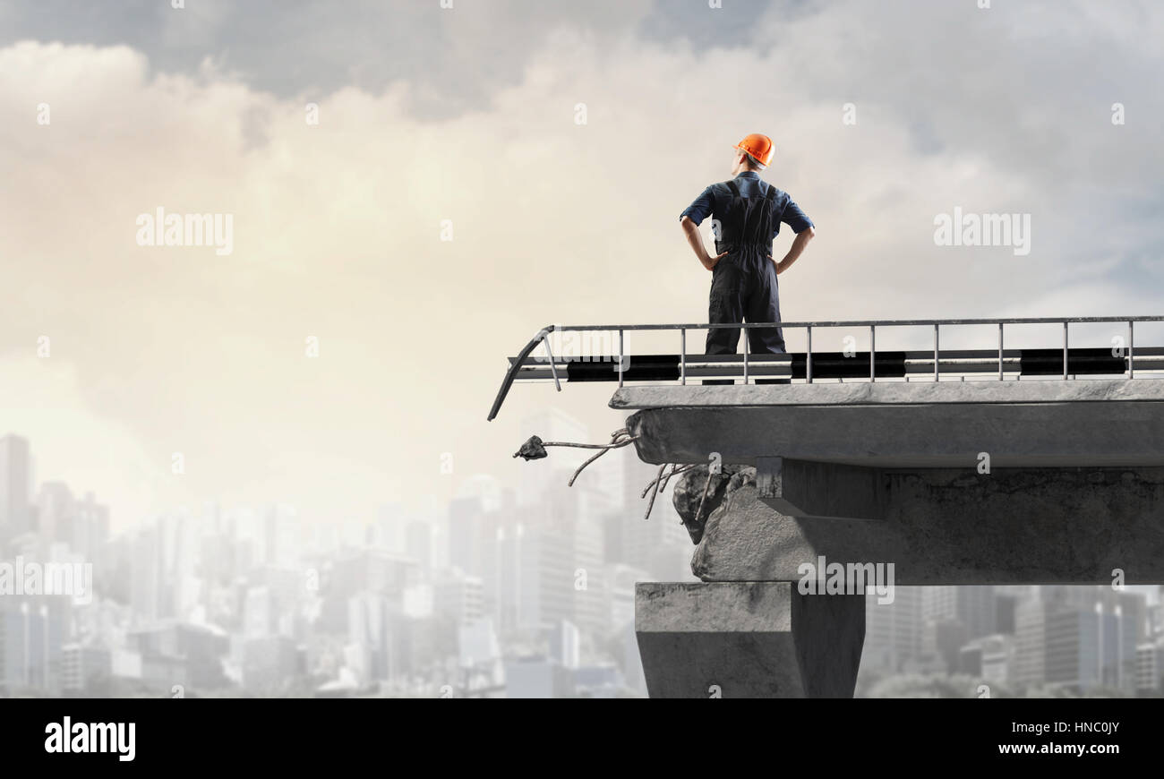Back view of builder man and destroyed bridge Stock Photo - Alamy