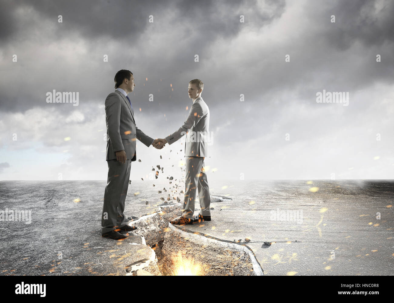 Two businessmen shaking hands across gap to deal or reunite Stock Photo ...