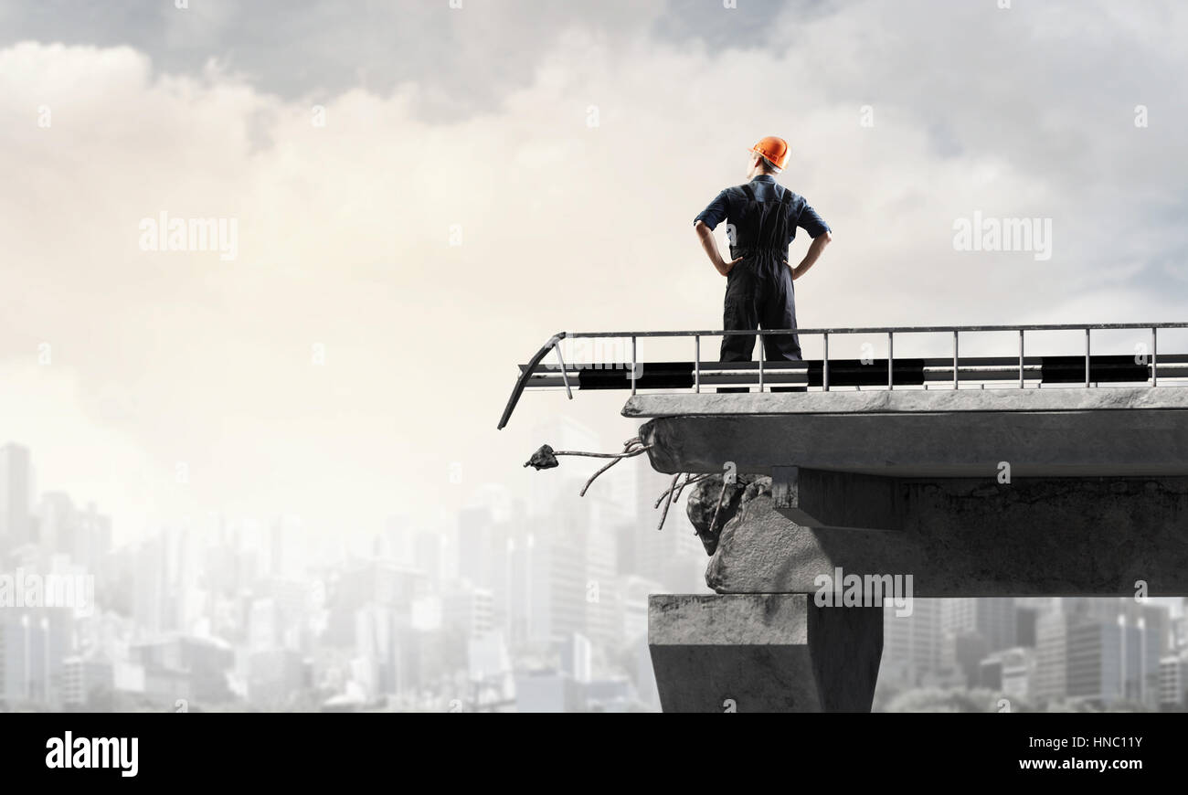 Back view of builder man and destroyed bridge Stock Photo - Alamy