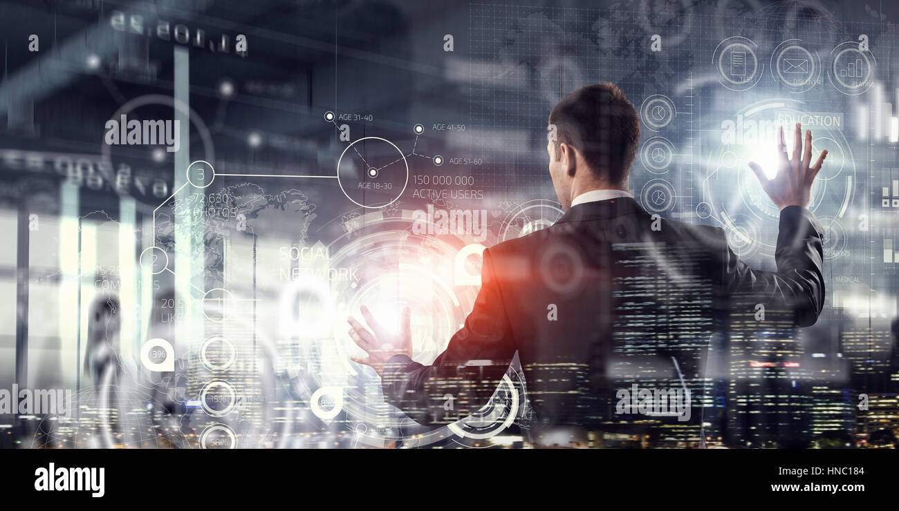 Back view of businessman working with virtual panel interface . Mixed ...