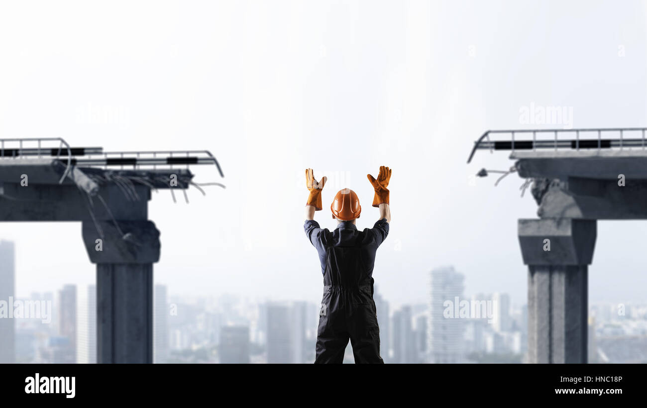Back view of builder man and destroyed bridge Stock Photo - Alamy