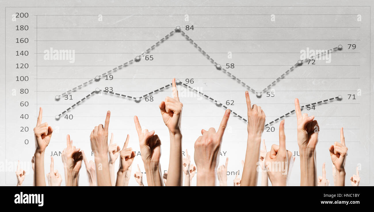 Row of raised hands showing different gestures and graphs at background ...