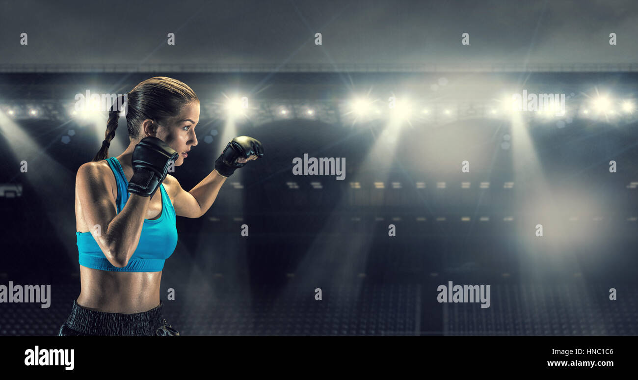 Young pretty boxer woman standing in light flashes. Mixed media Stock ...