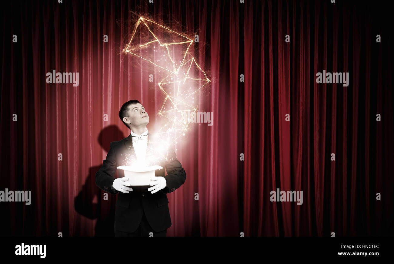 Man magician with cylinder hat doing tricks Stock Photo - Alamy
