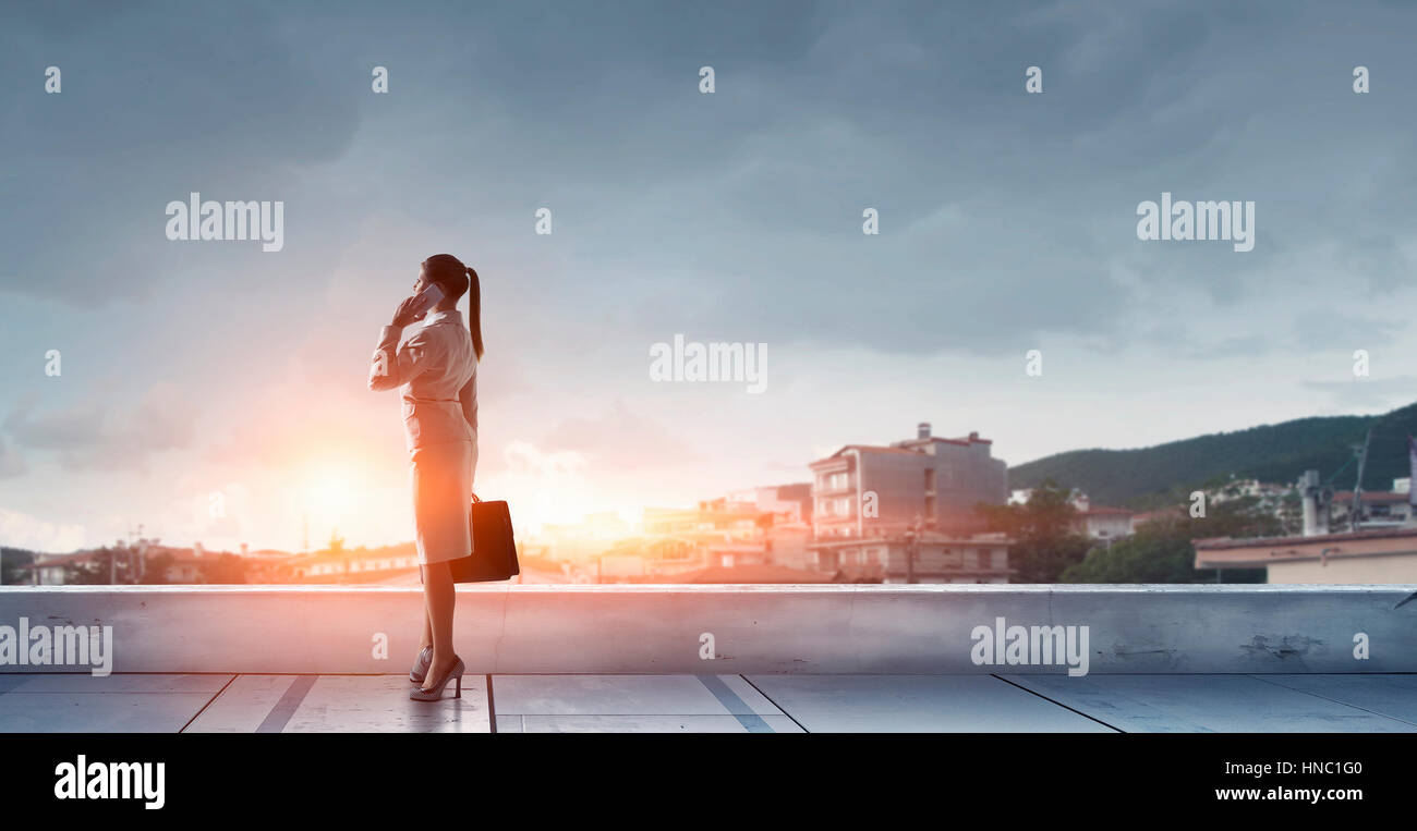 Young business lady on top of building against cityscape Stock Photo ...