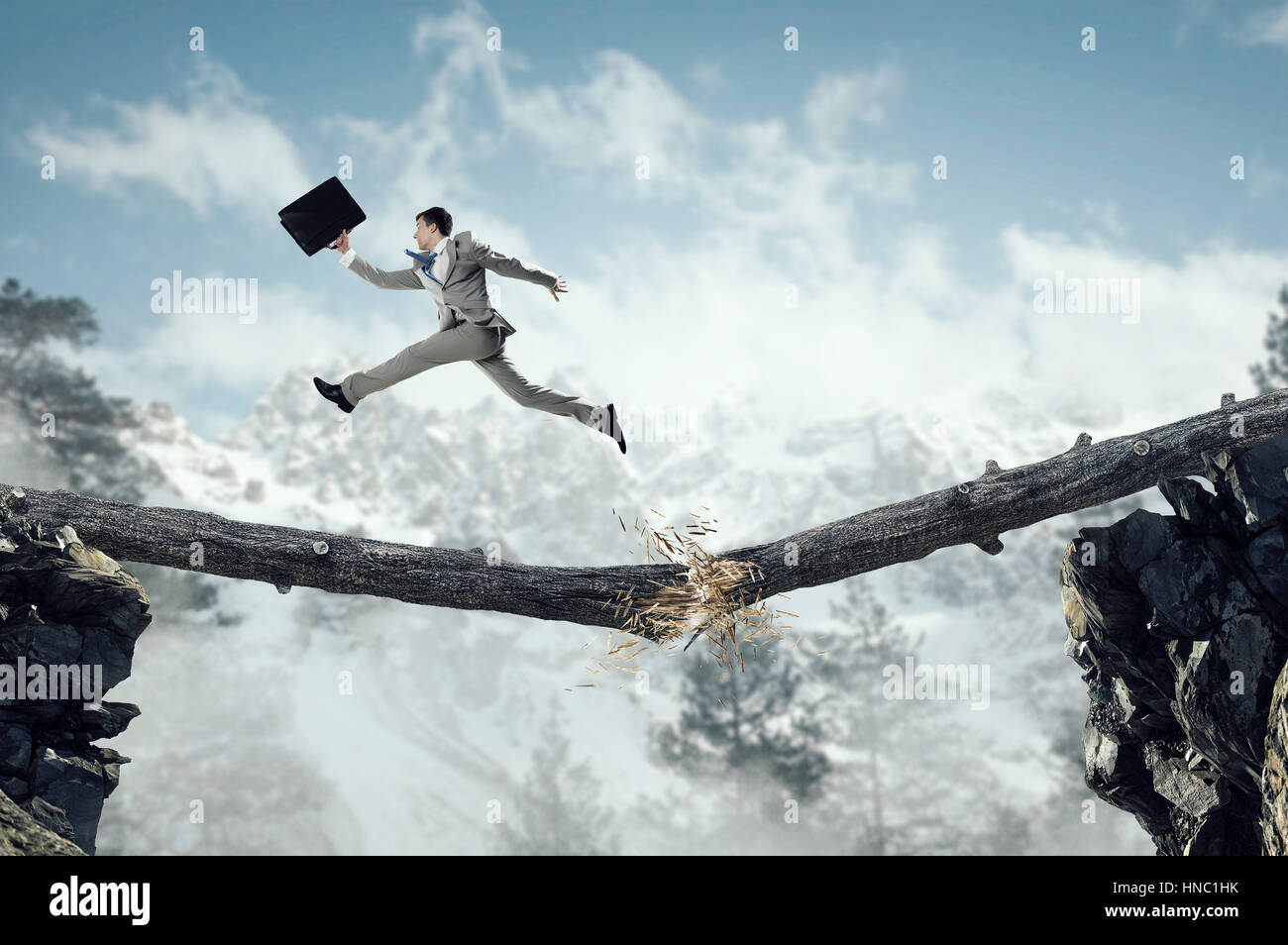 Young successful businessman jumping over gap. Risk and challenge ...