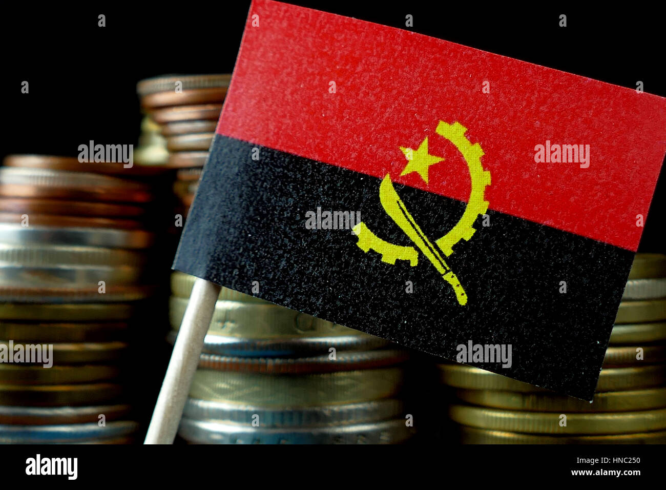 Angolan flag waving with stack of money coins macro Stock Photo - Alamy
