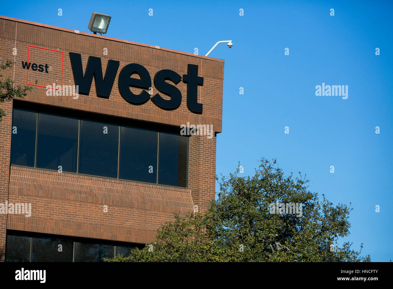 A logo sign outside of a facility occupied by the West Corporation in ...
