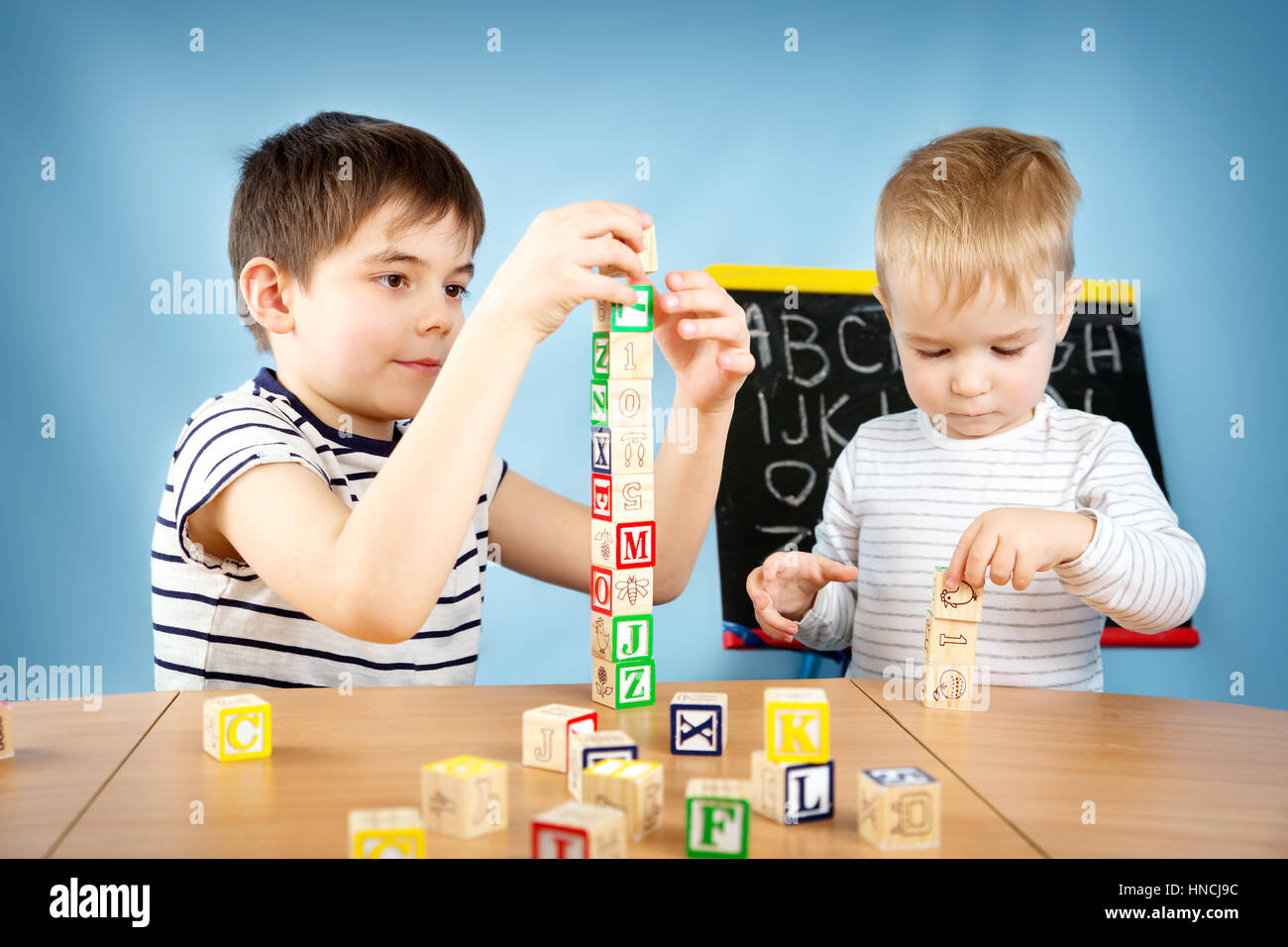 Children playing with cubes on the table Stock Photo - Alamy