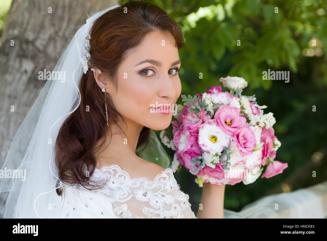 Stunning young bride posing in a green summer garden Stock Photo - Alamy