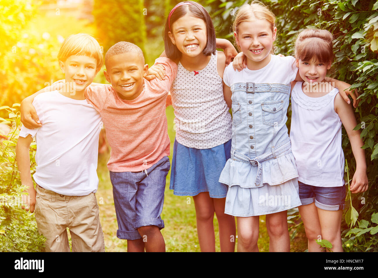 Group of children smiling as friends together in summer in garden Stock ...