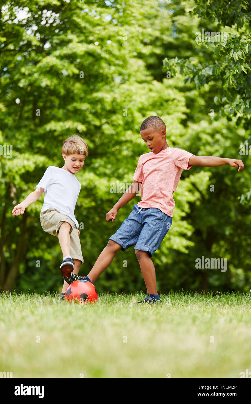 Kids practicing sport in summer playing soccer at the park Stock Photo ...