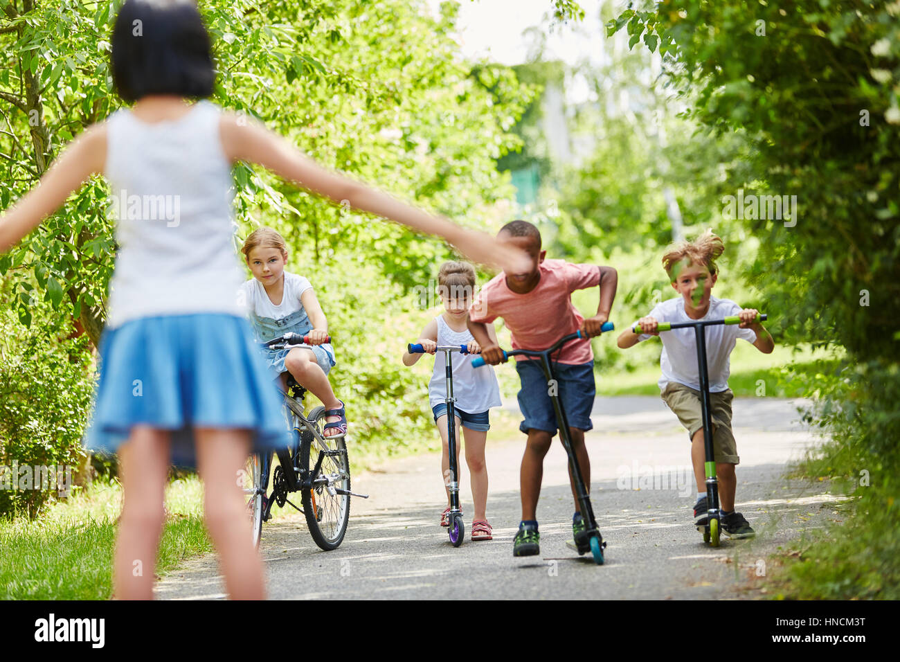 Children at bike and scooters race in the park in summer Stock Photo ...