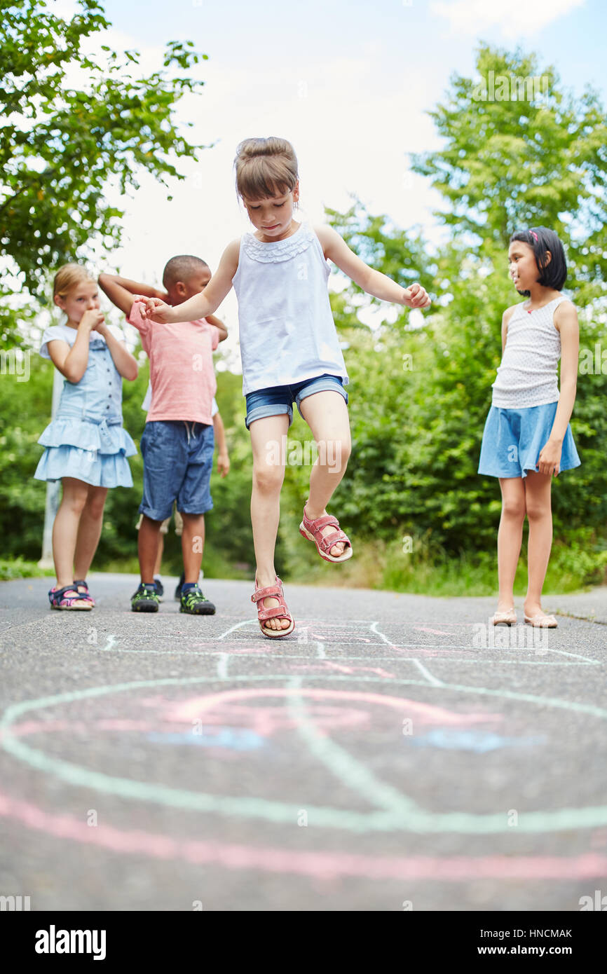 Girl playing hopscotch painted with chalk on the street Stock Photo - Alamy