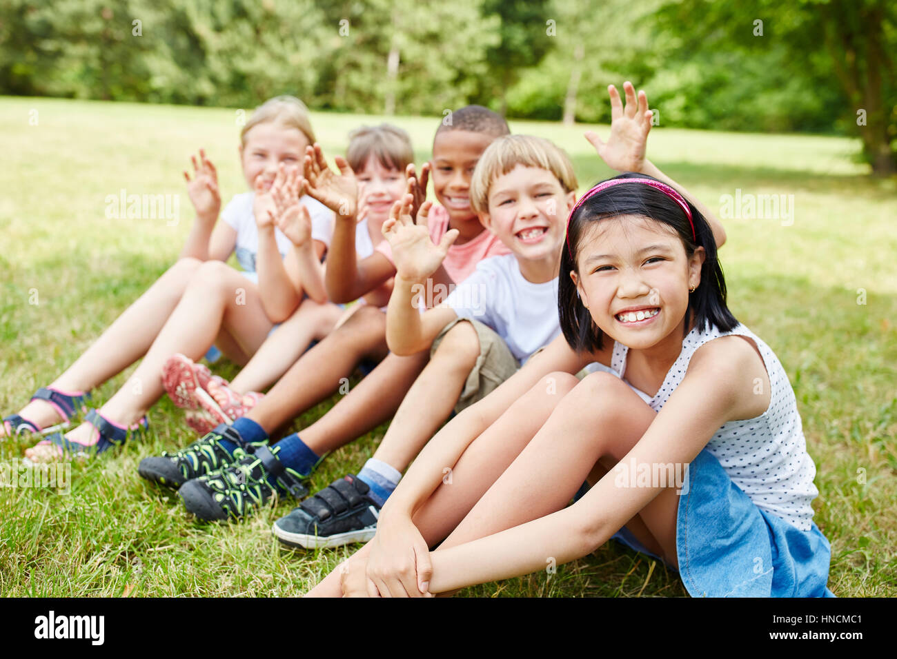 Multicultural children in school trip to nature wave happy Stock Photo ...