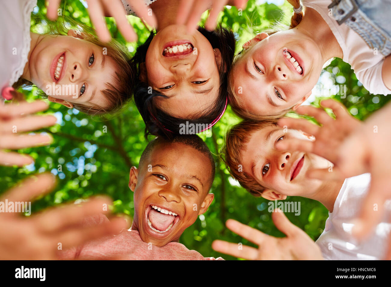 Kids have fun and make circle together as team Stock Photo - Alamy