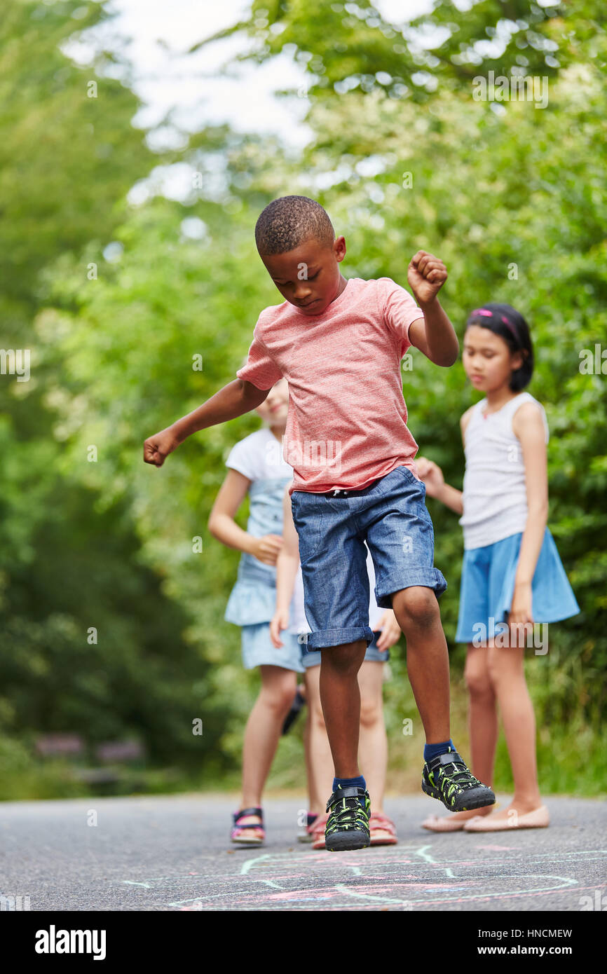 African boy playing hopscotch on the street Stock Photo - Alamy