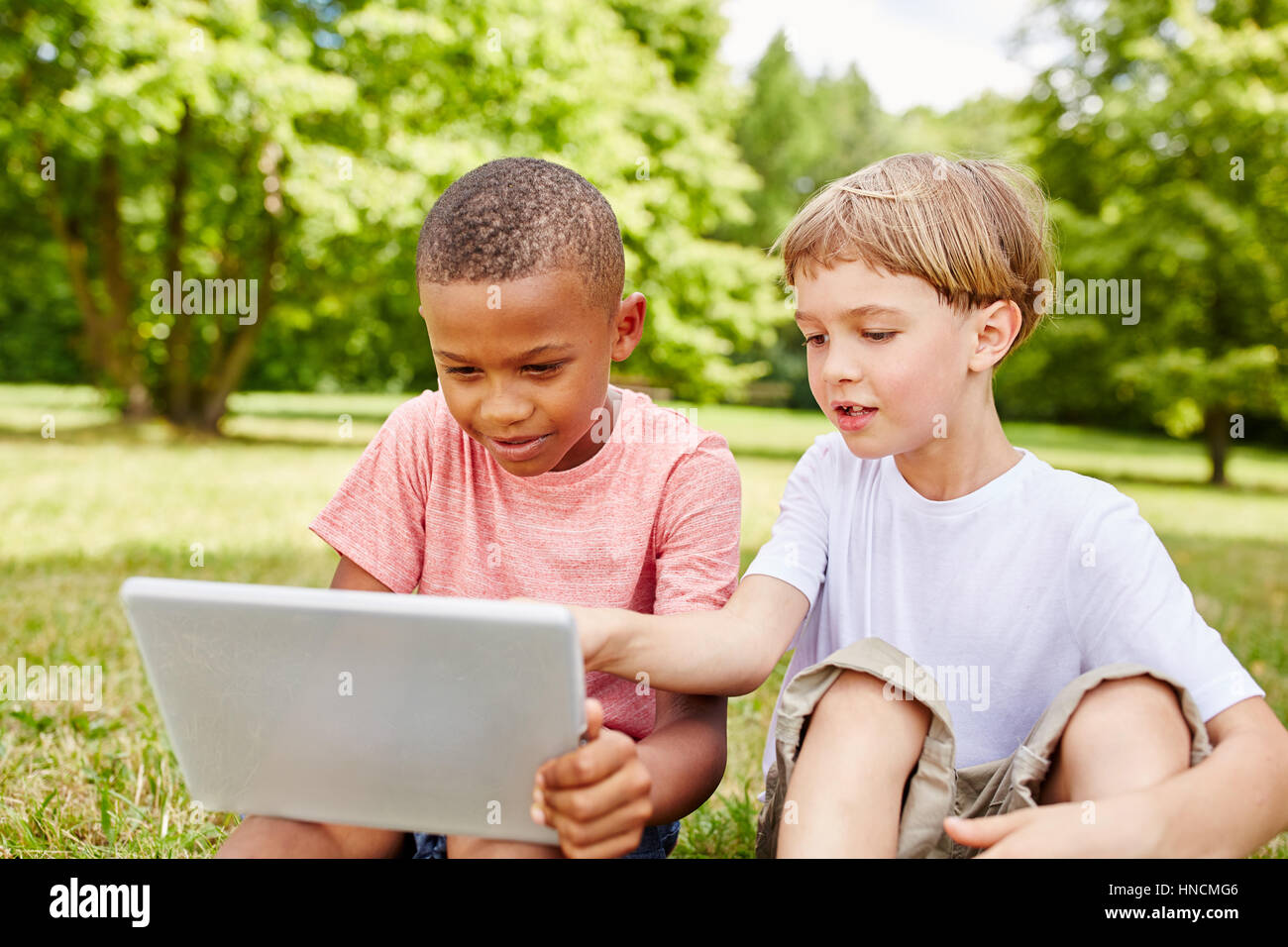 Two boys with laptop learning in teamwork about internet and social ...