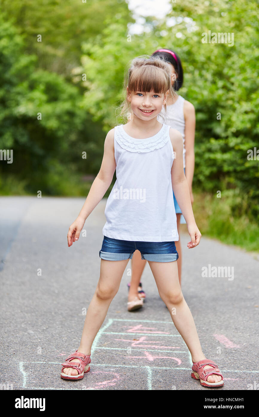 Girl and friend play hopscotch on the street and have fun Stock Photo ...