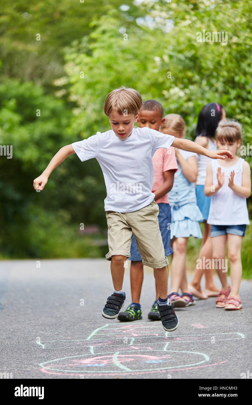 Boy jumping during hopscotch competition on the street Stock Photo - Alamy