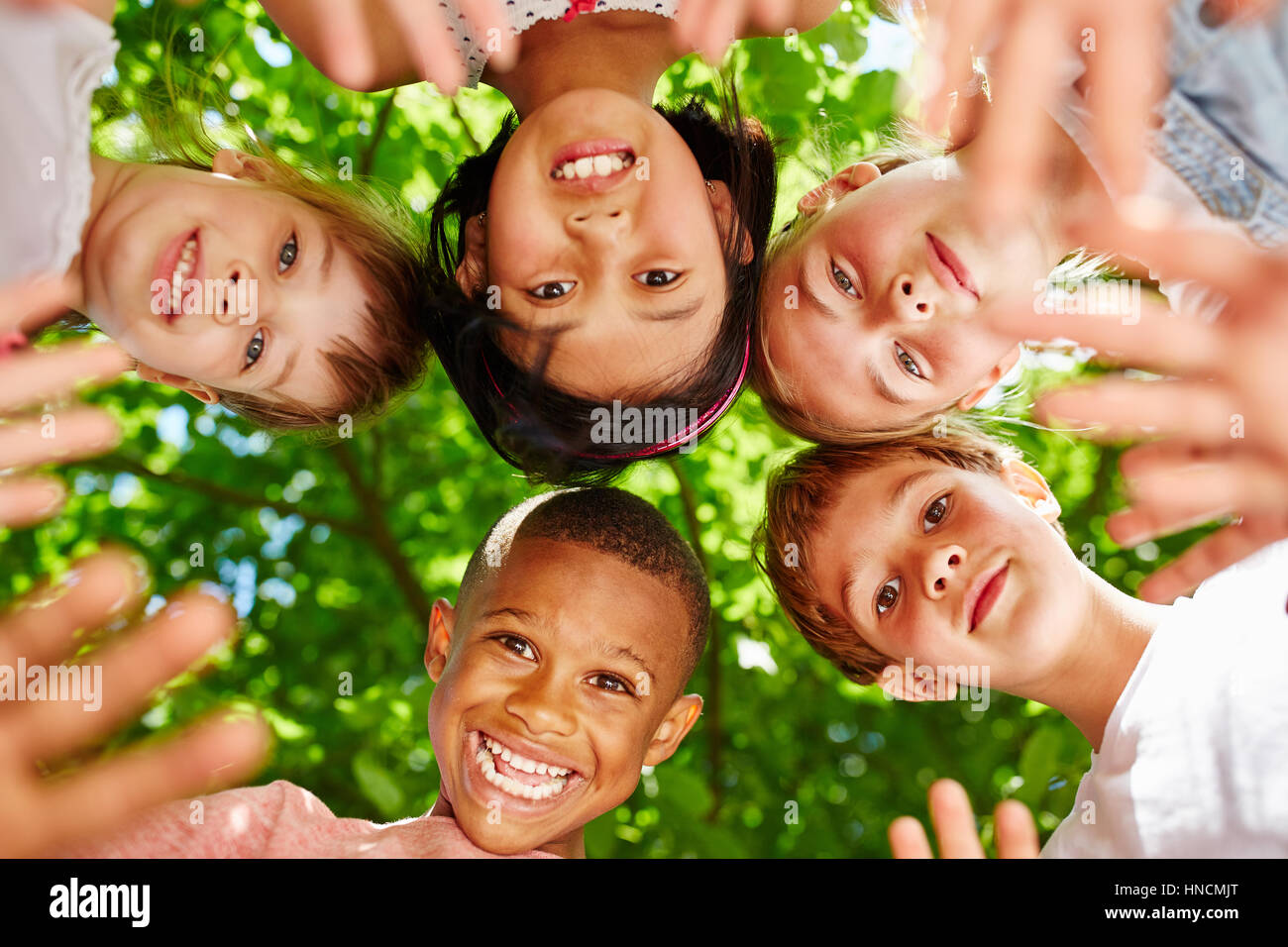 Interracial team of children standing in circle as motivation und ...