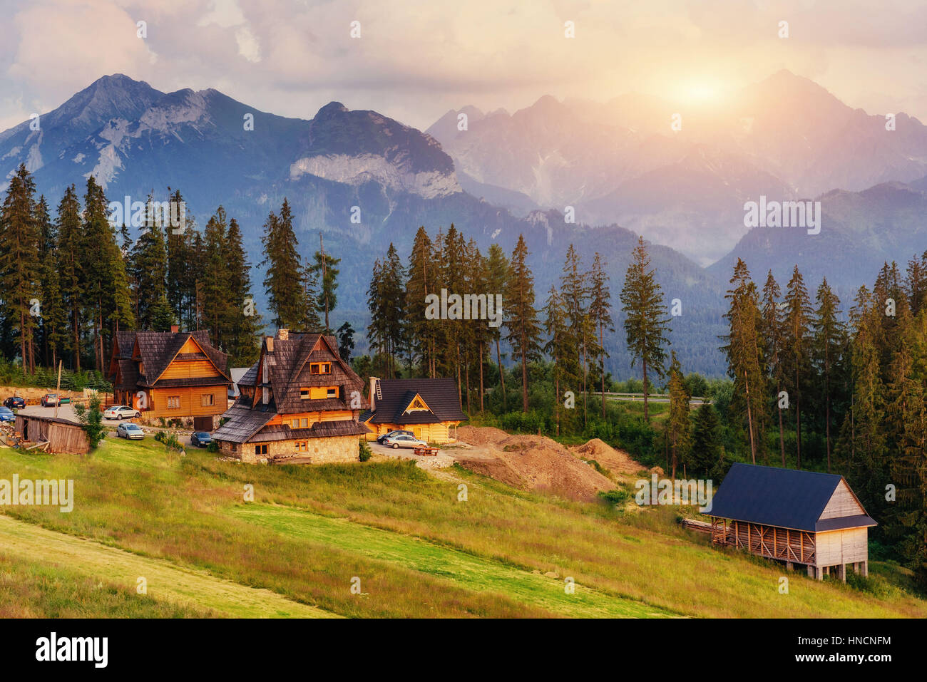 Traditional wooden house in the mountains on a green field Mount Stock ...