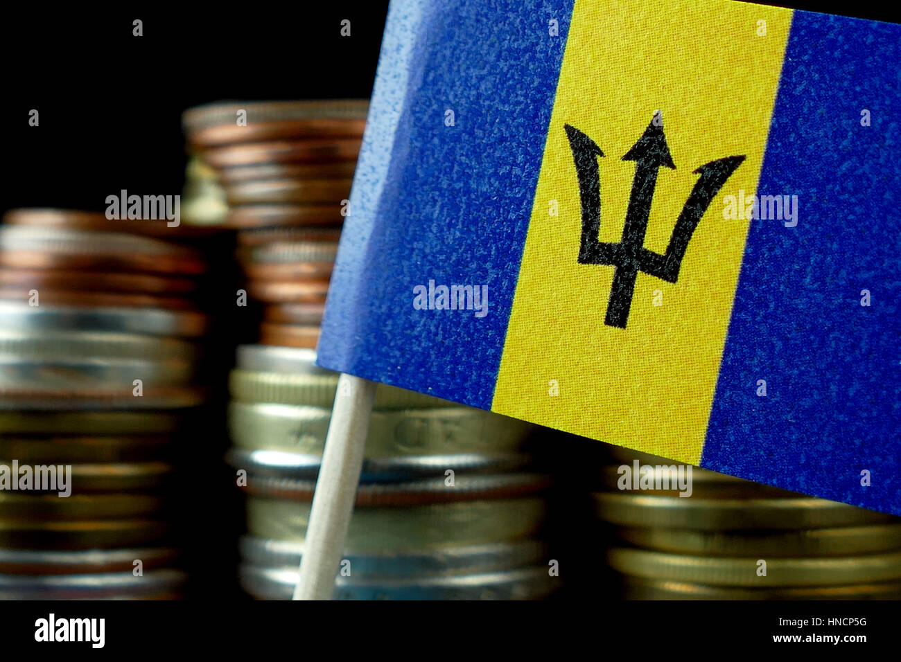 Barbados flag waving with stack of money coins macro Stock Photo - Alamy