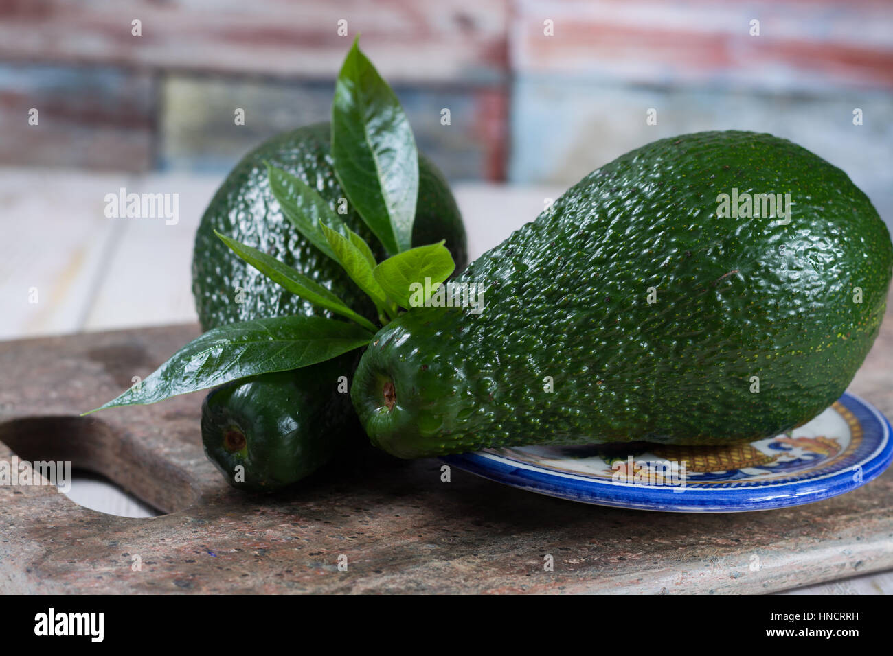 Green ripe fresh avocado with leaves on granite plank Stock Photo - Alamy