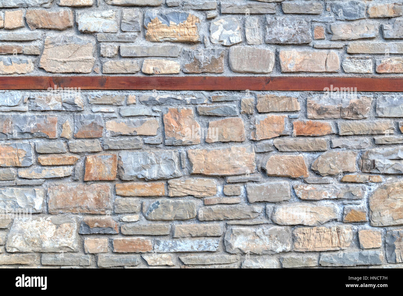 Stone wall background with wooden beam Stock Photo - Alamy