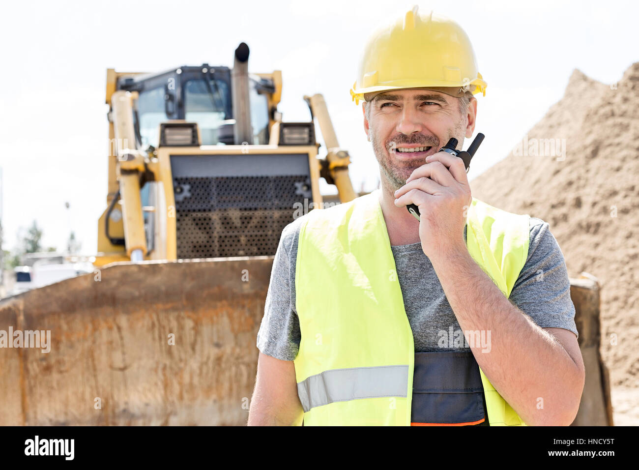 Confident supervisor using walkie-talkie at construction site Stock ...