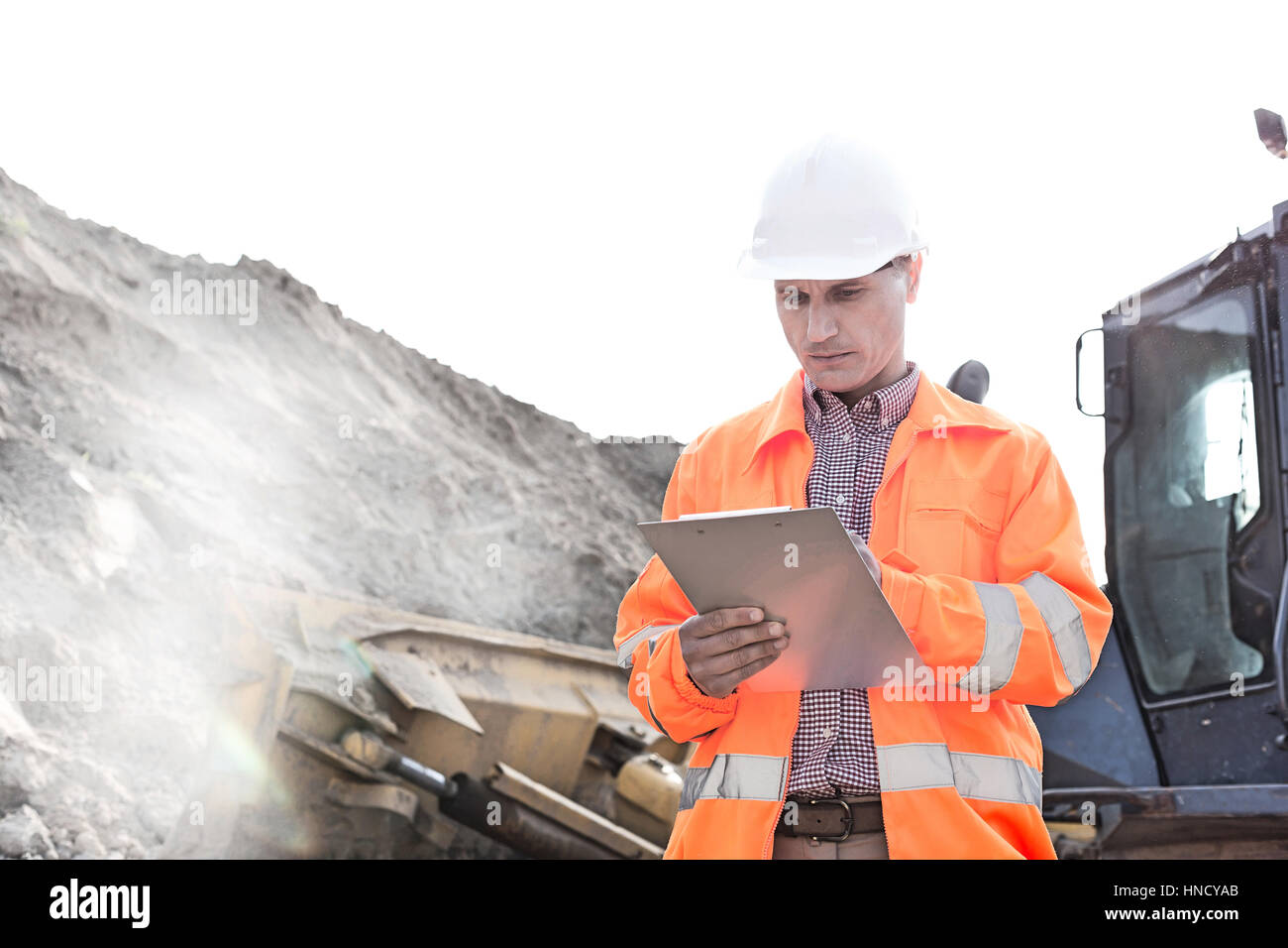 Engineer reading clipboard at construction site Stock Photo - Alamy