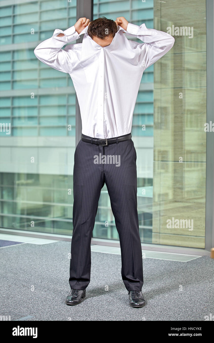 Businessman removing shirt at office Stock Photo - Alamy