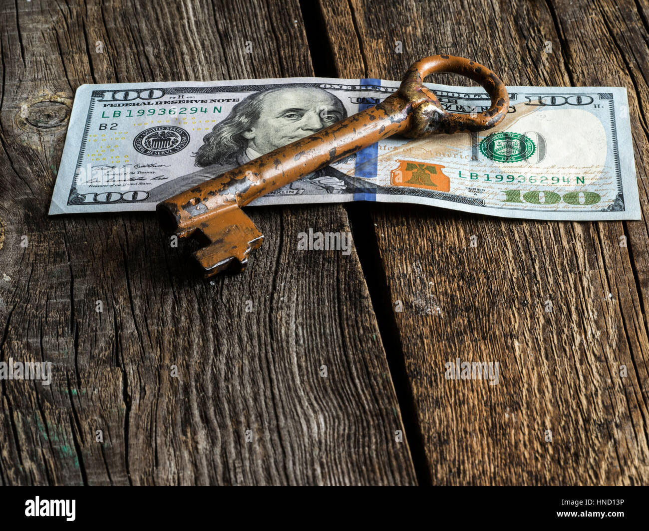 vintage key on 100 dollars banknote on old wooden weavered background ...
