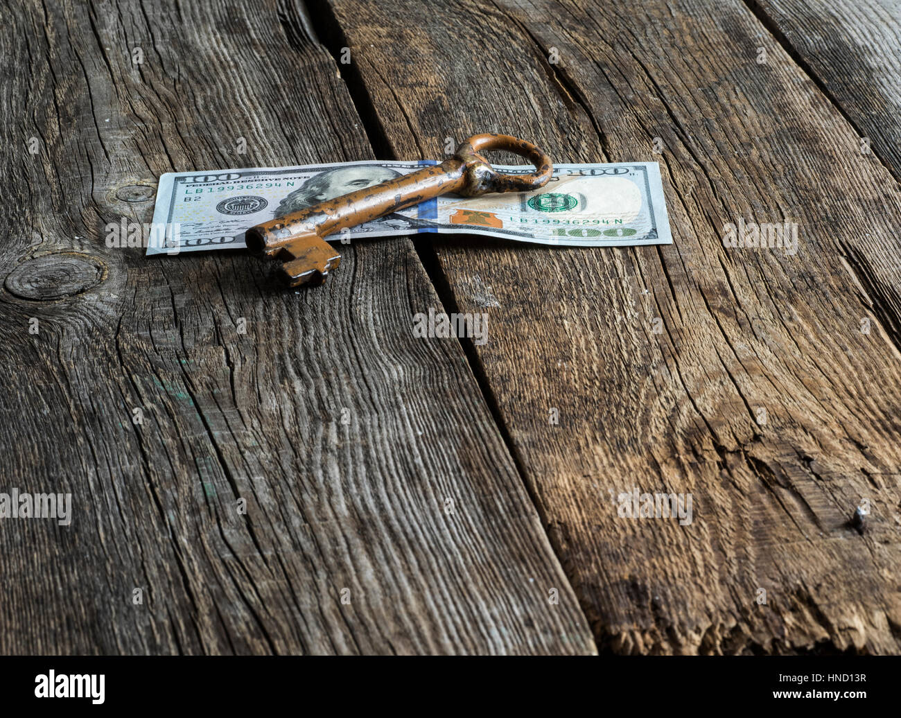 vintage key on 100 dollars banknote on old wooden weavered background ...