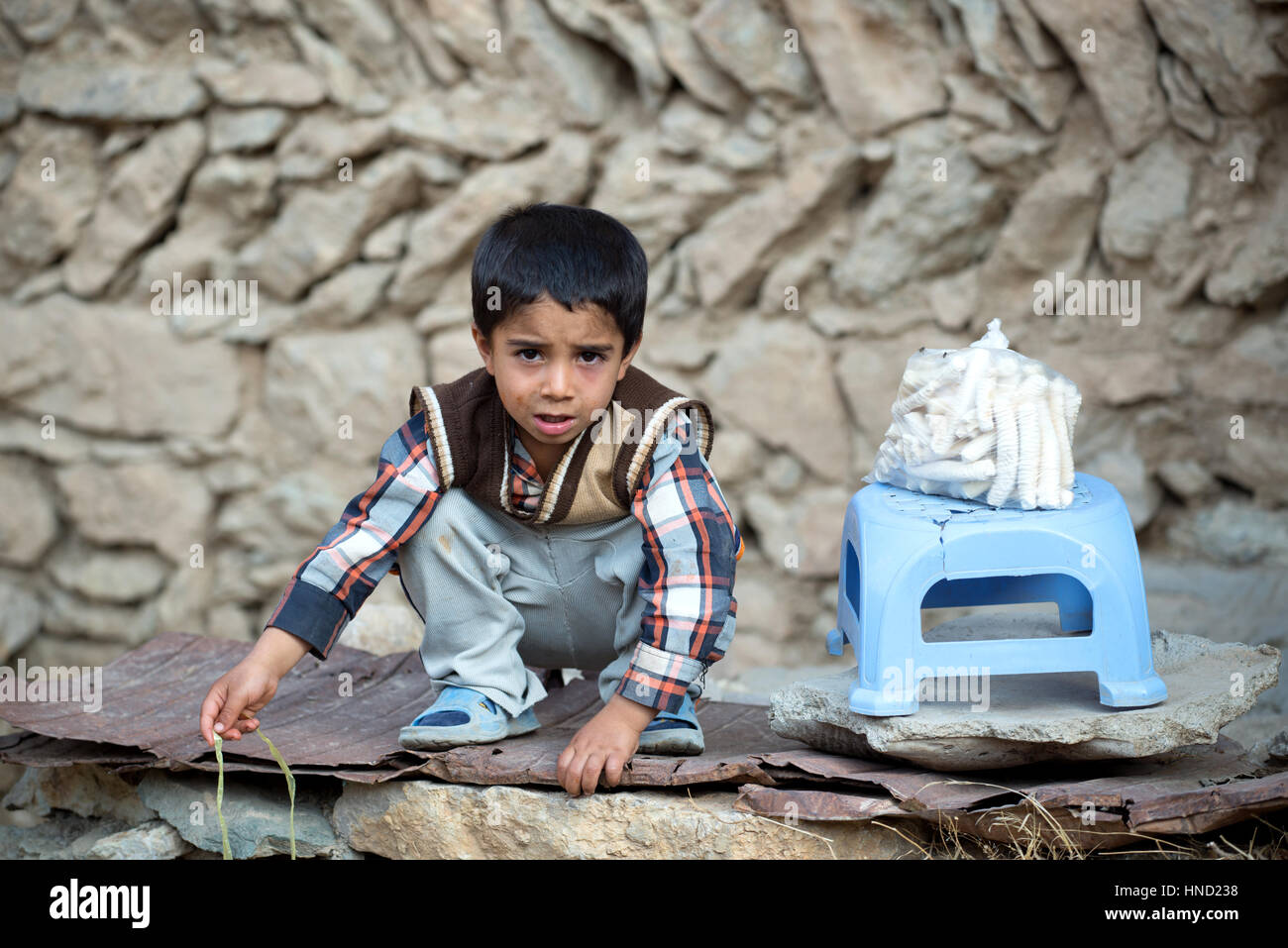 A young kurdish boy on the roof of a traditional house, Palangan ...