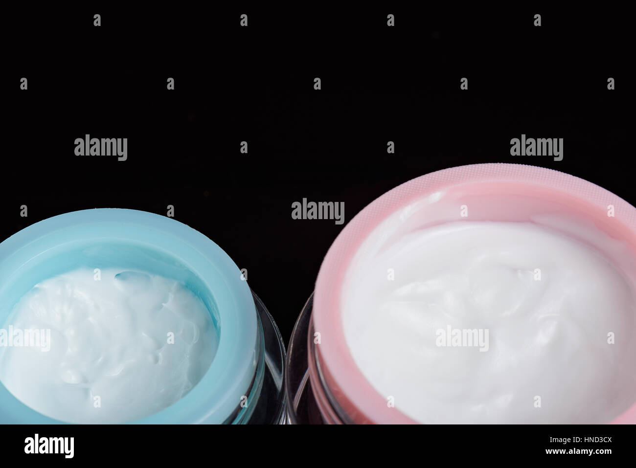 open face cream containers isolated on black background closeup with ...